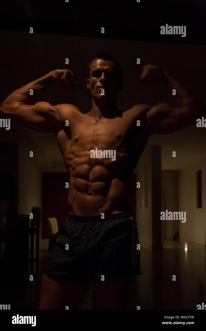 Close up of body builder with black short, night time scene at inside ...