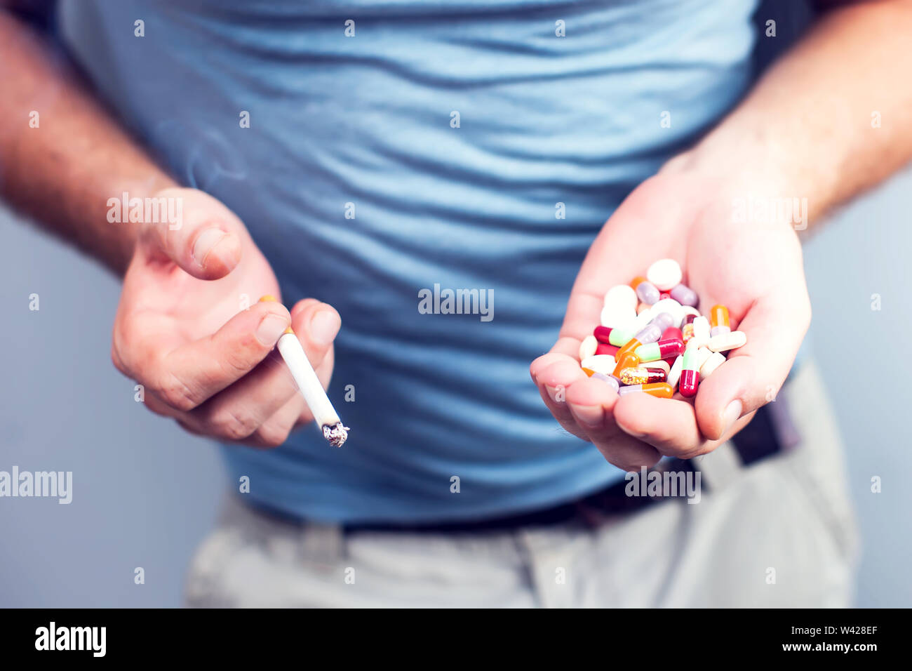 Lighted cigarette in hand with medicines isolated - Cigarette smoking ...