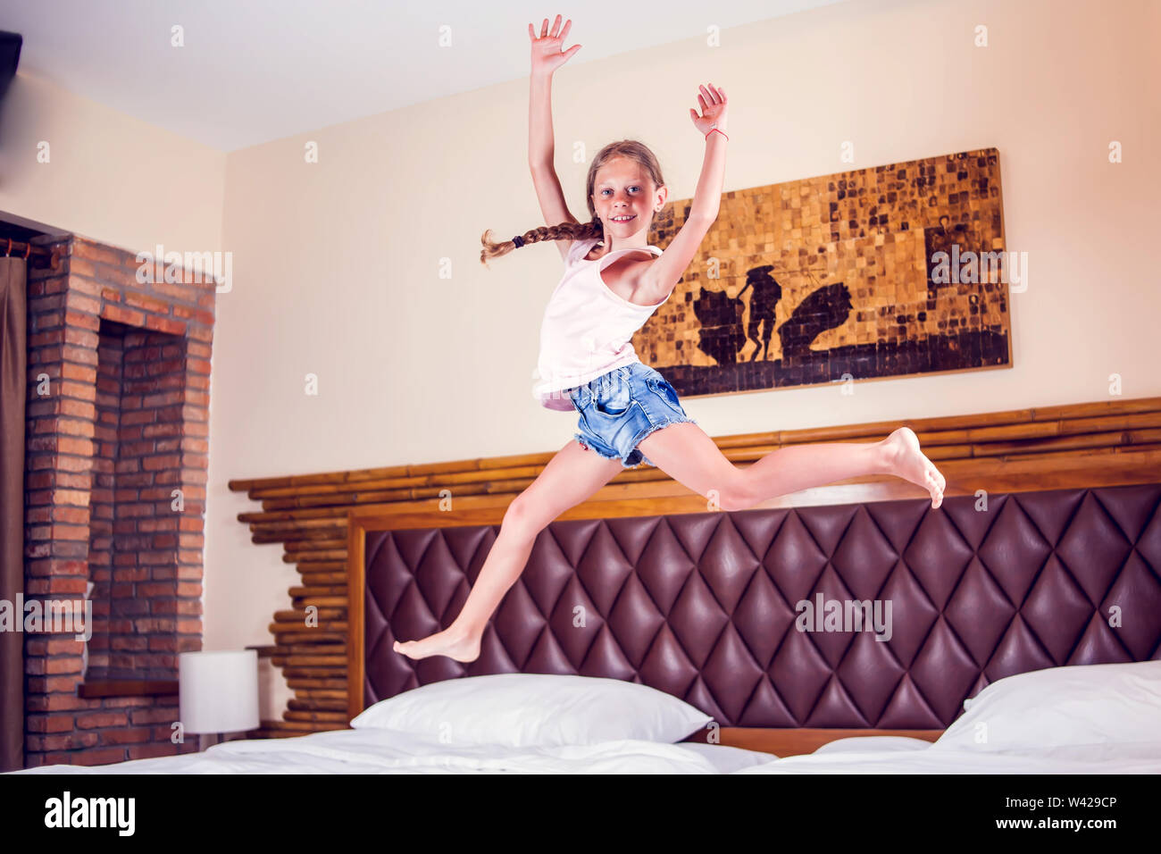Young Girl Having Fun Jumping On Bed In Bedroom Stock Photo - Alamy