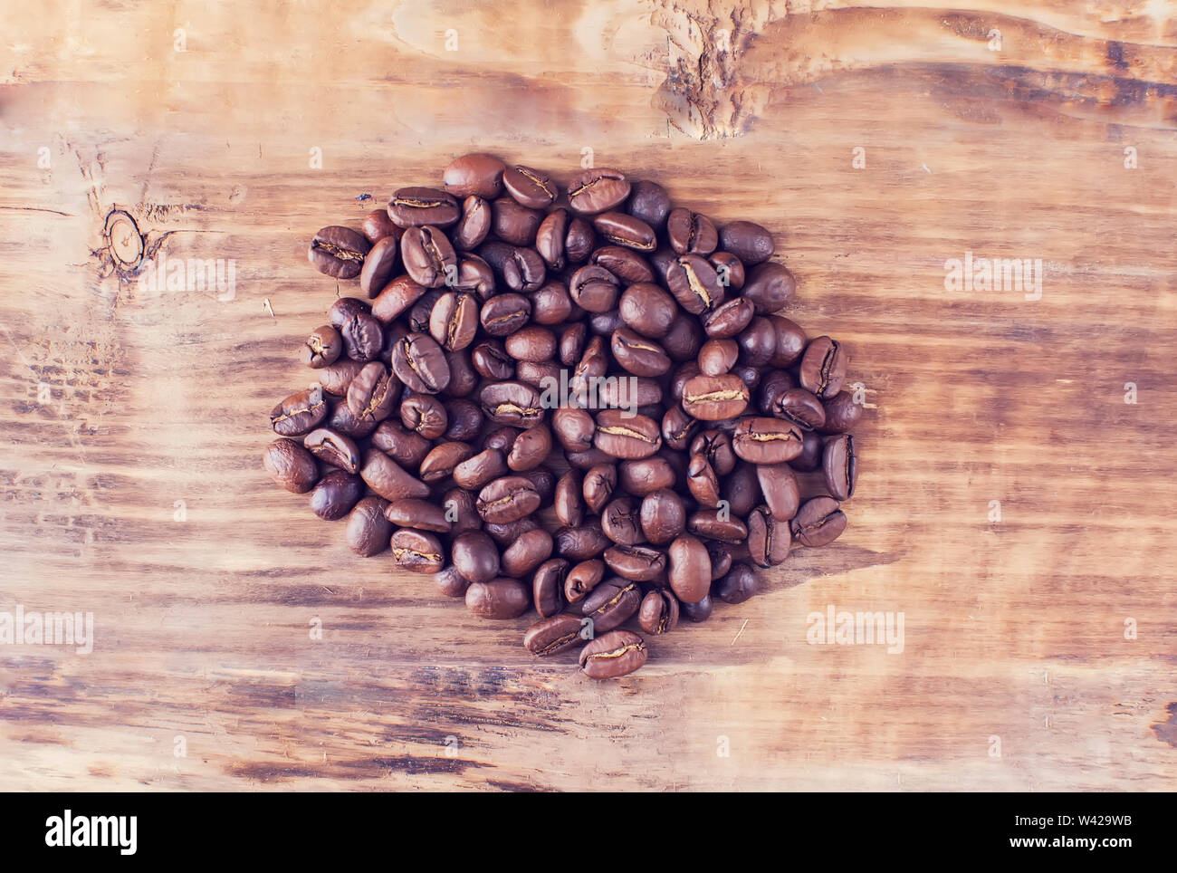 Roasted coffee beans on rustic wood background Stock Photo - Alamy