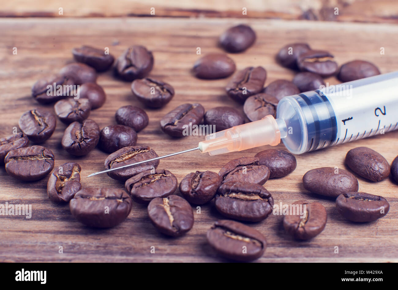 Coffee dependence syringe with beans of coffee Stock Photo - Alamy