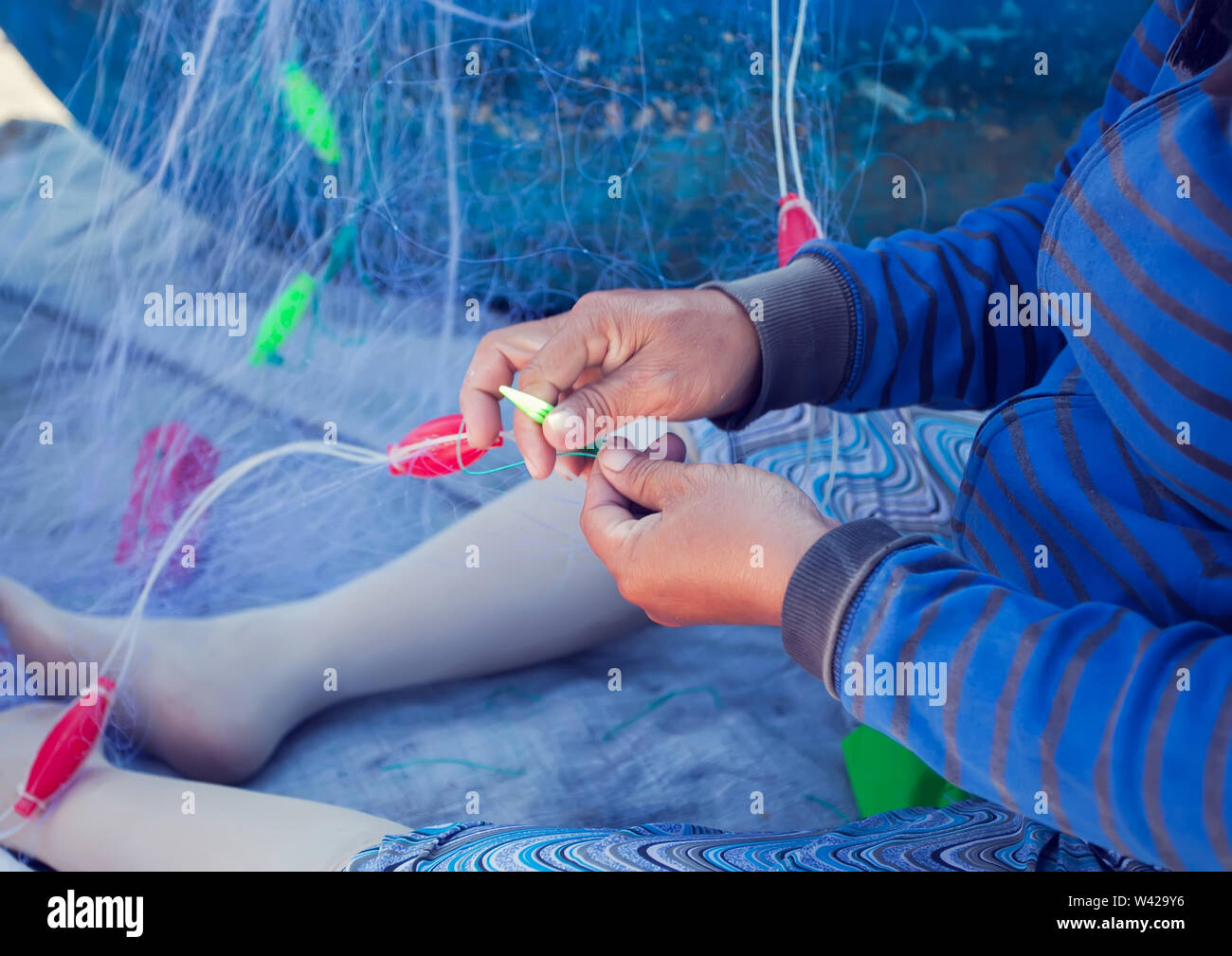 Hands woman weaving fishing nets in traditional way Stock Photo - Alamy