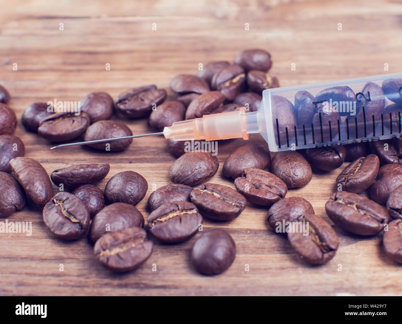 Coffee dependence syringe with beans of coffee Stock Photo - Alamy