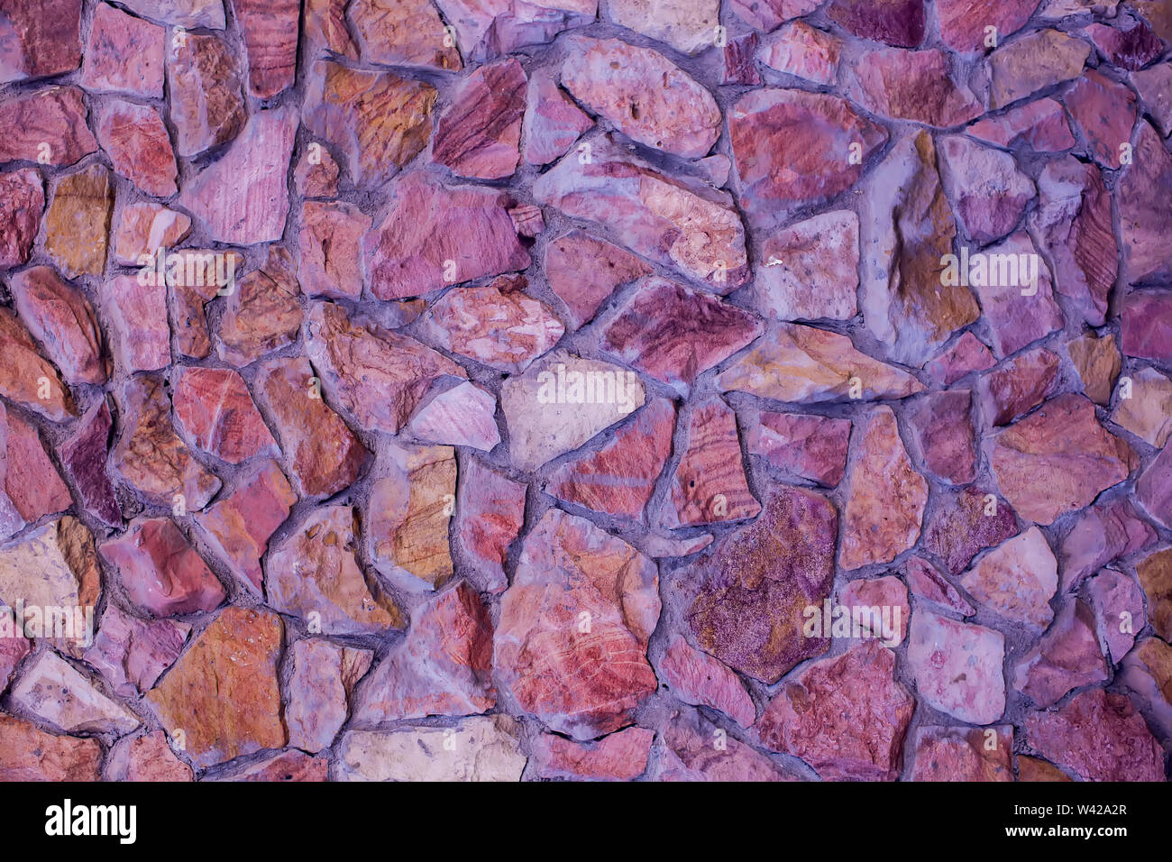 Part of a red stone wall, for background or texture Stock Photo - Alamy