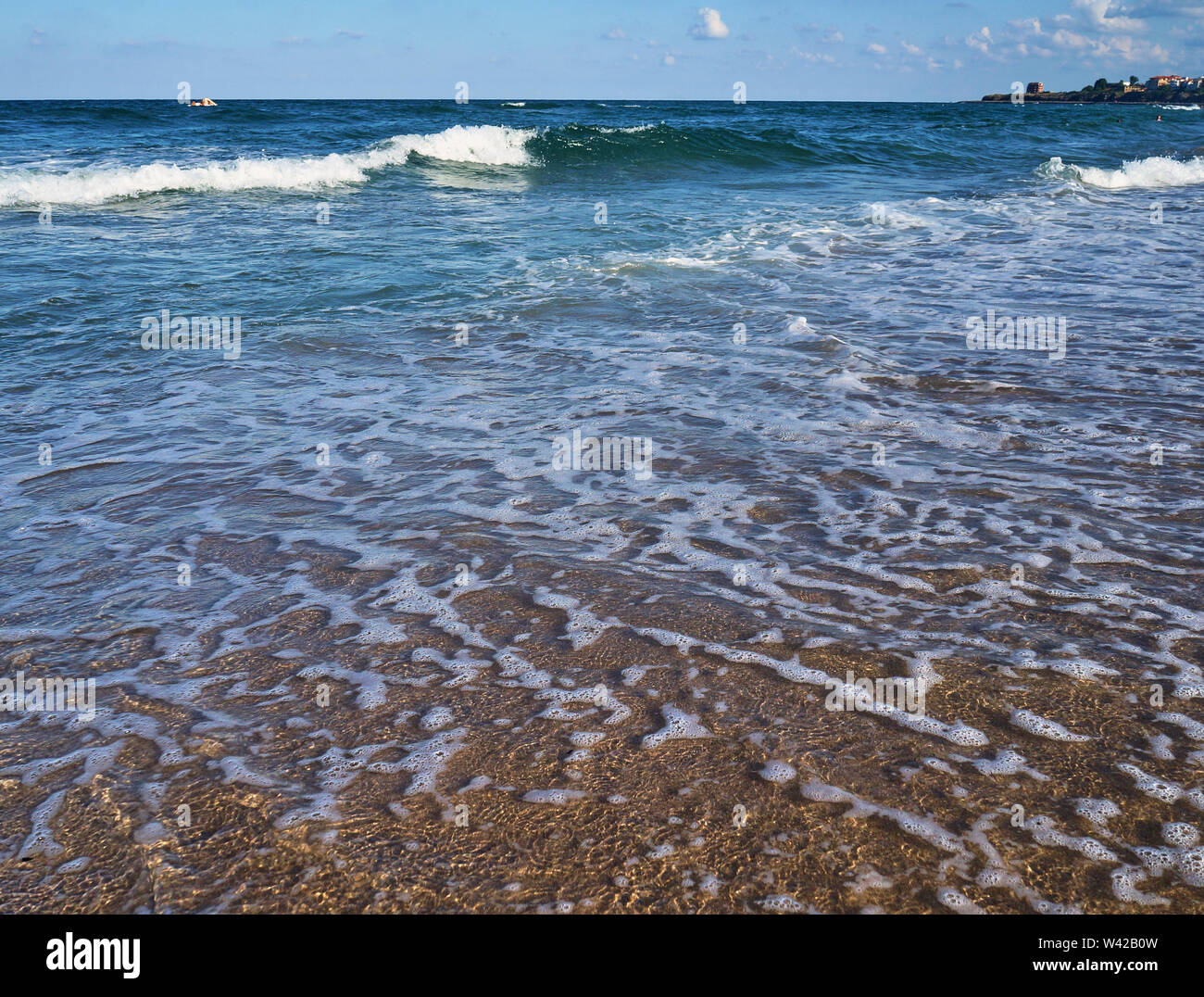 Surf and waves on the sandy shore of the Black Sea on a sunny summer ...