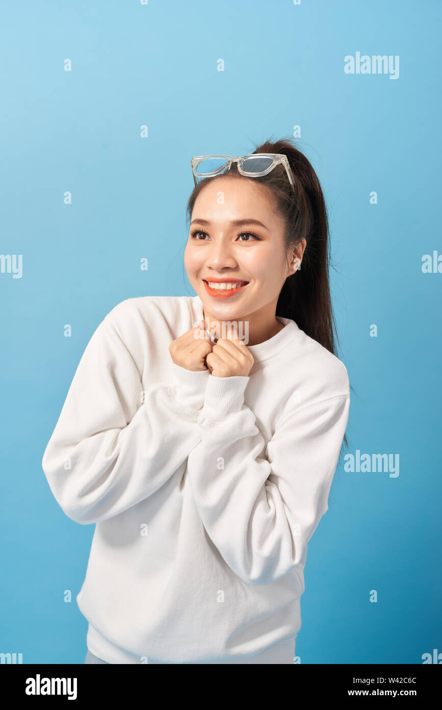 Happy woman keeps hands under chin looks joyfully at camera, notices ...