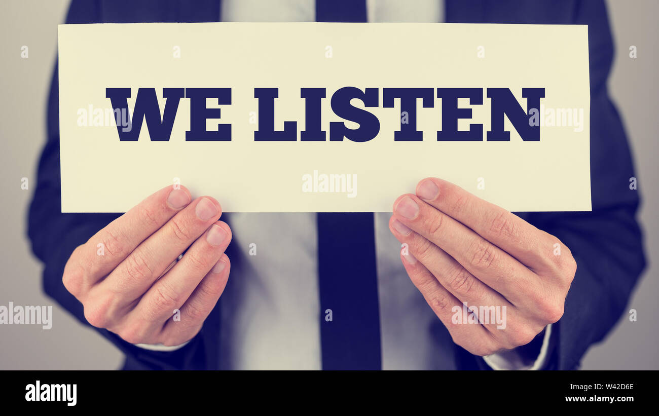 Retro image of male hands holding We listen sign. Conceptual of ...