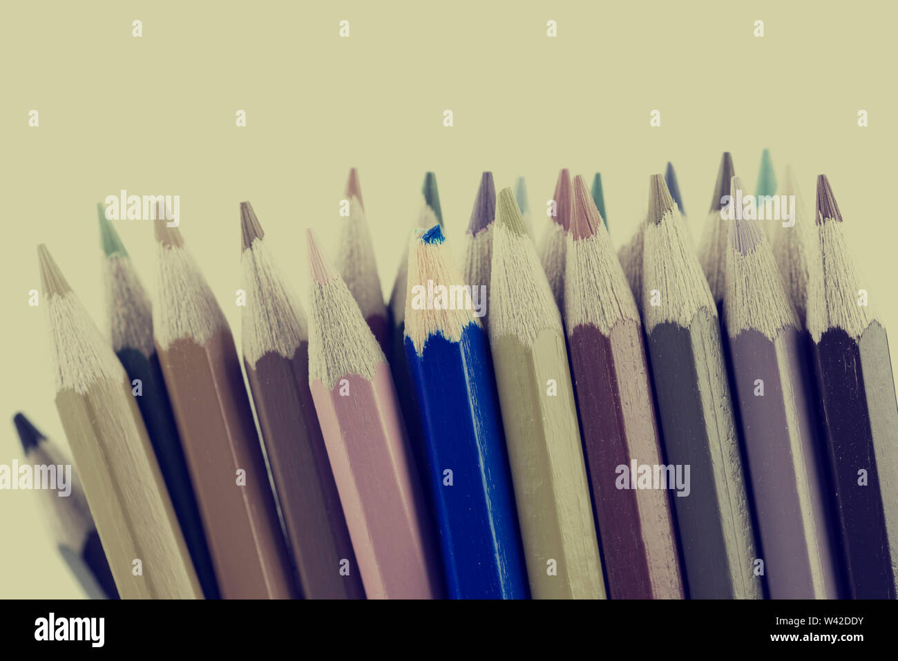 Retro toned image of a collection of colored pencil crayons with ...