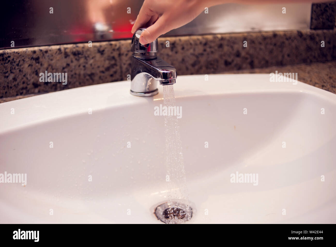 Open chrome faucet water washbasin in the bathroom Stock Photo - Alamy