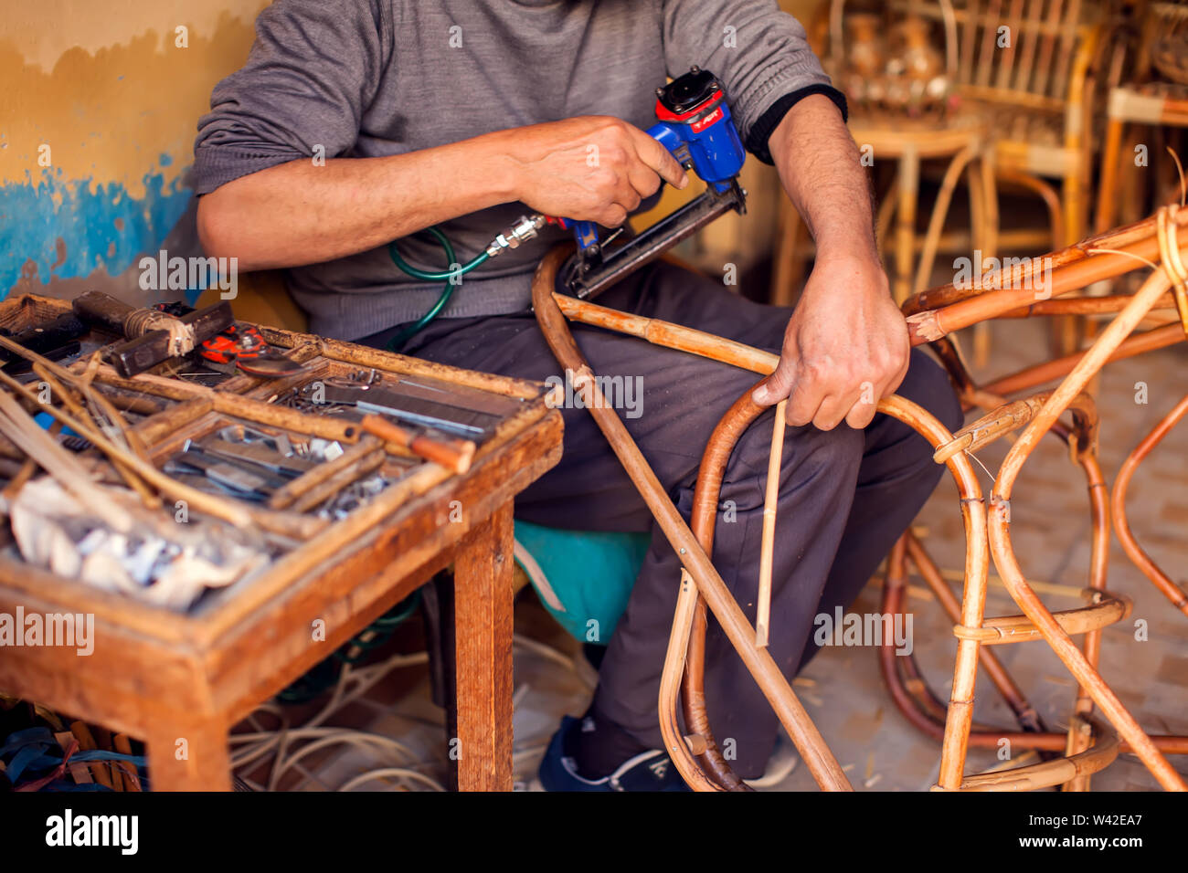 Man in process of manufacturing furniture rattan chair and table Stock ...