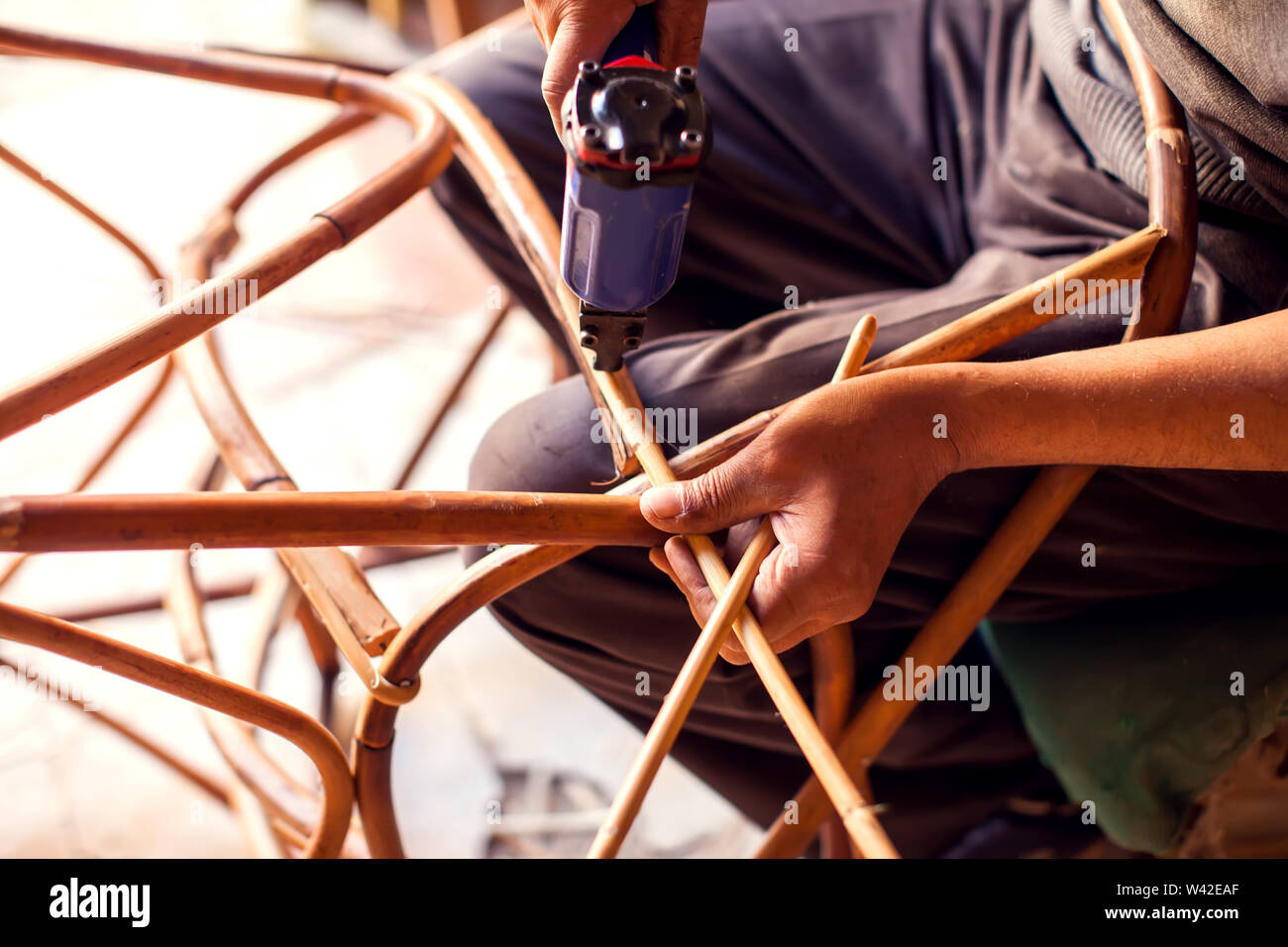 Man in process of manufacturing furniture rattan chair and table Stock ...