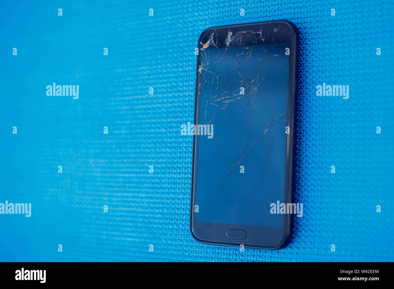 Mobile smartphone with broken screen on blue background Stock Photo - Alamy