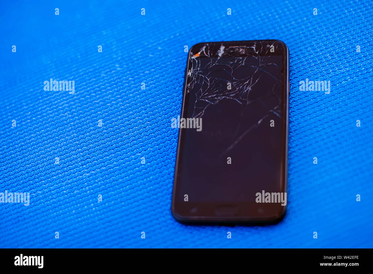 Mobile smartphone with broken screen on blue background Stock Photo - Alamy