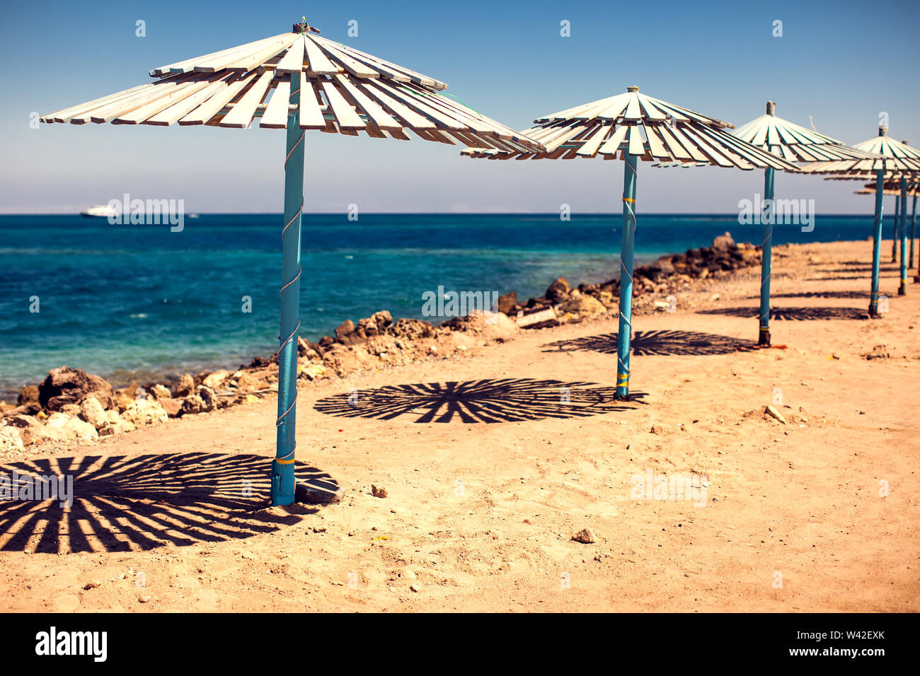 Sun umbrellas on a beach with sea background. Summer, vacation concept ...