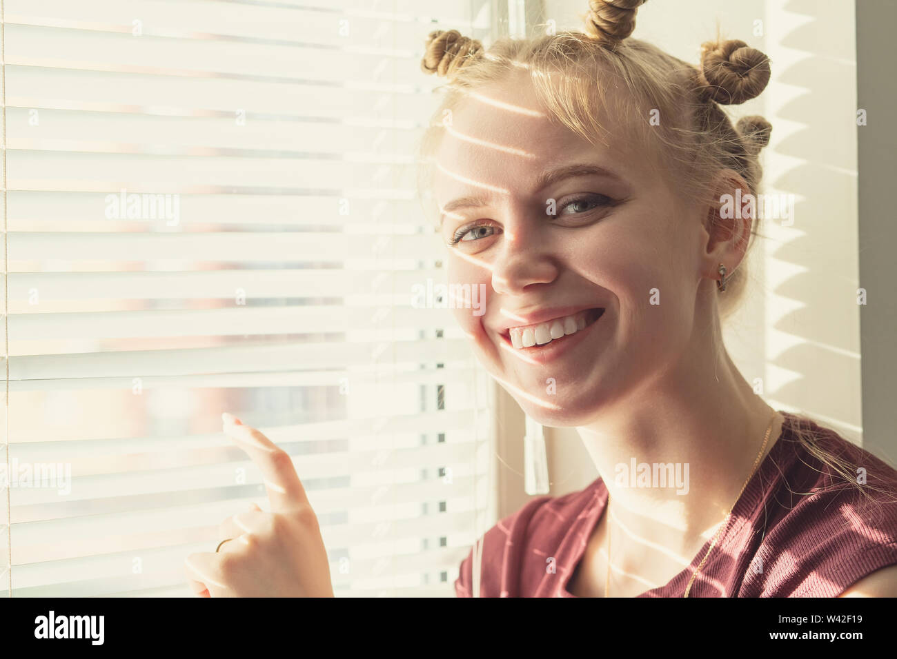 Woman looking through blinds hi-res stock photography and images - Alamy