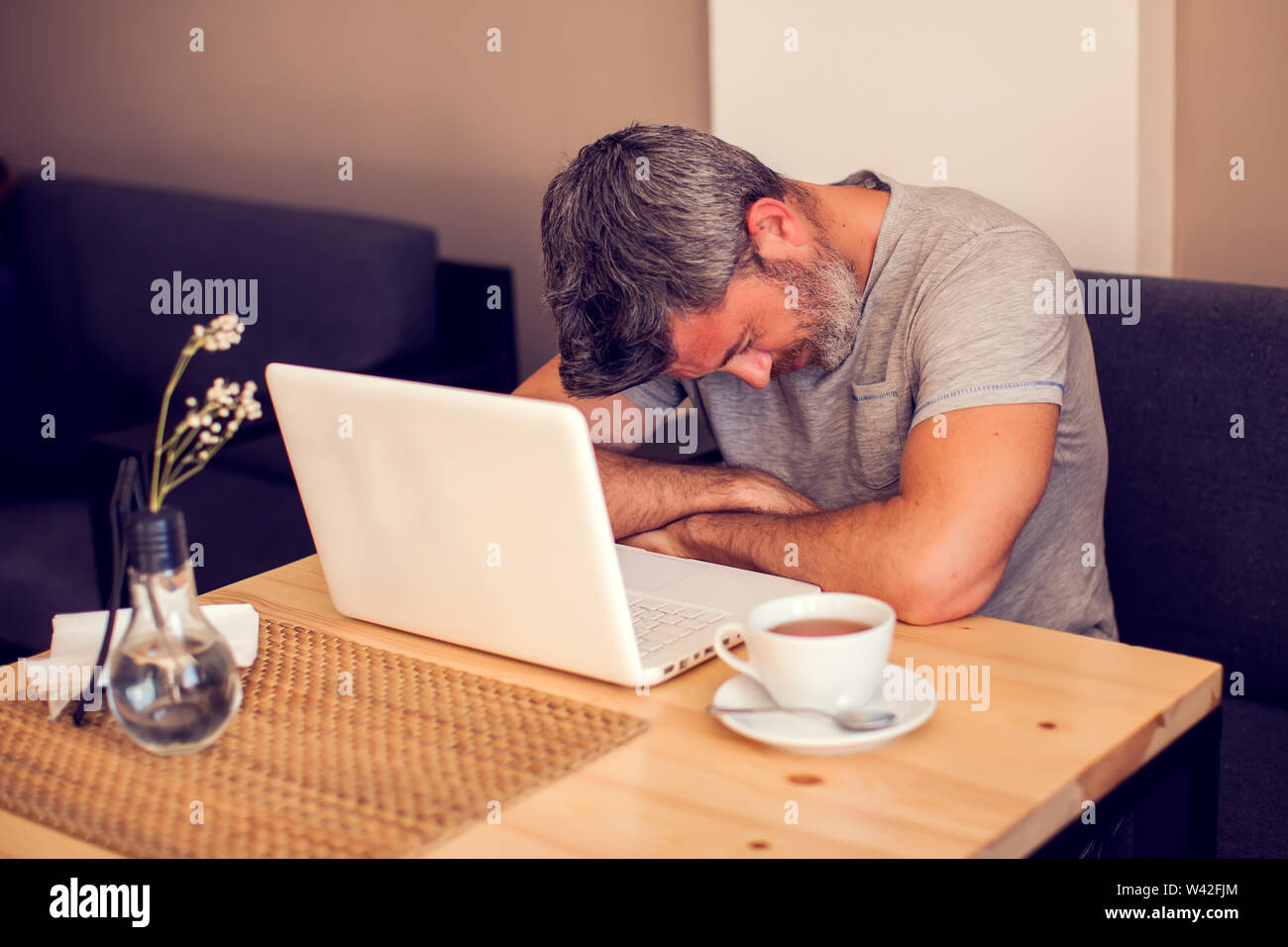 Man having a headache in front of laptop. People, health care and ...