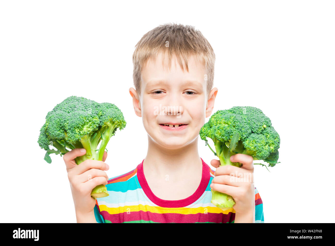 portrait of a boy with broccoli in hands on white background in studio ...