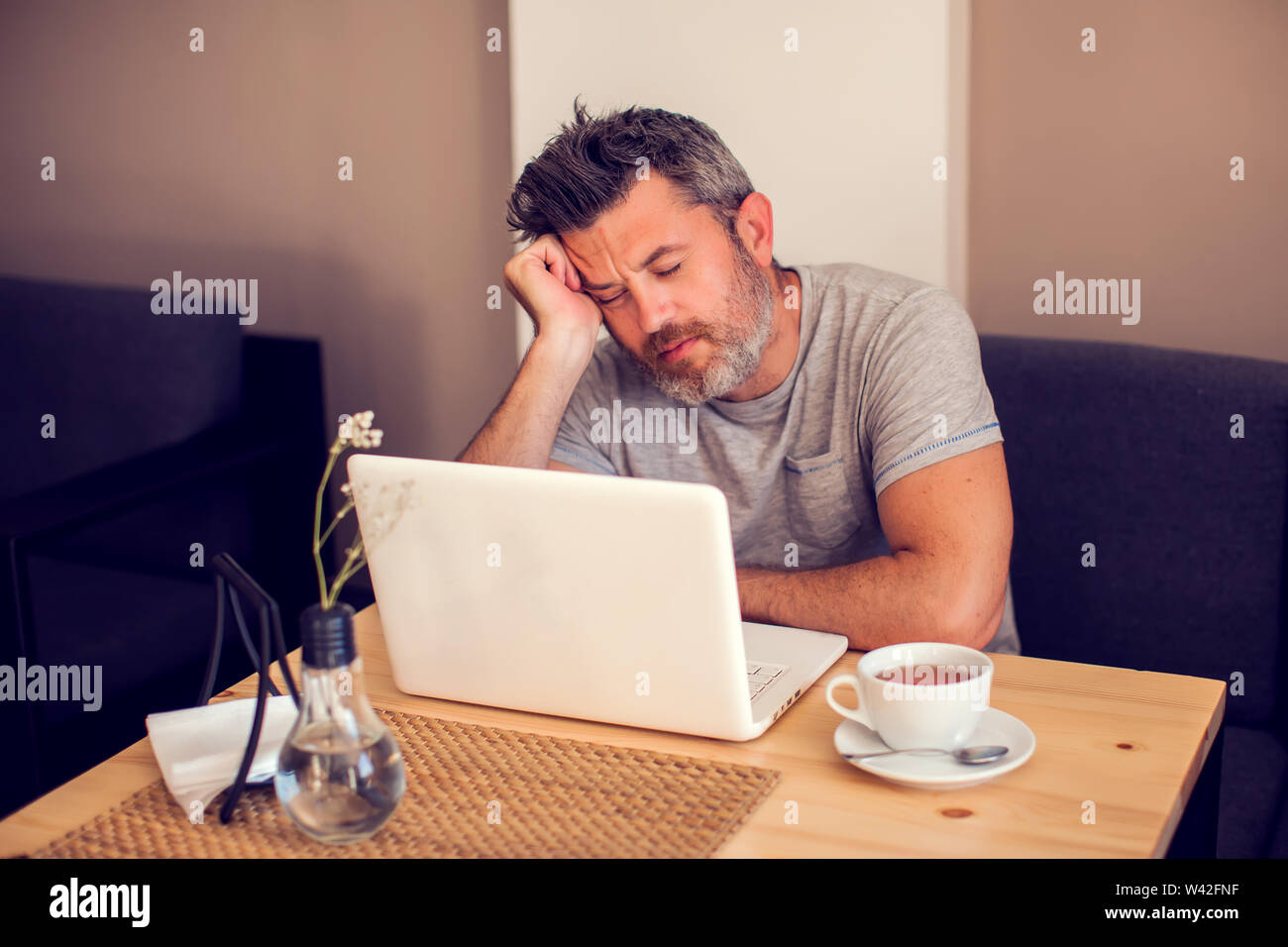 Man having a headache in front of laptop. People, health care and ...
