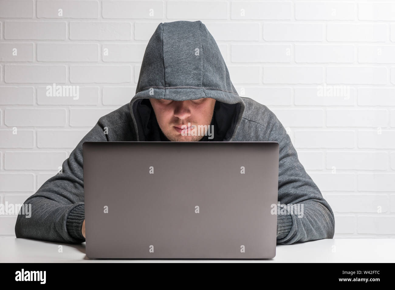 male criminal in the hood hacker spreads the virus to the Internet ...