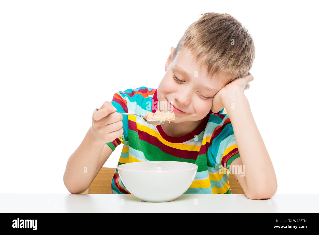 healthy food - oatmeal for breakfast, a boy with a plate on a white ...