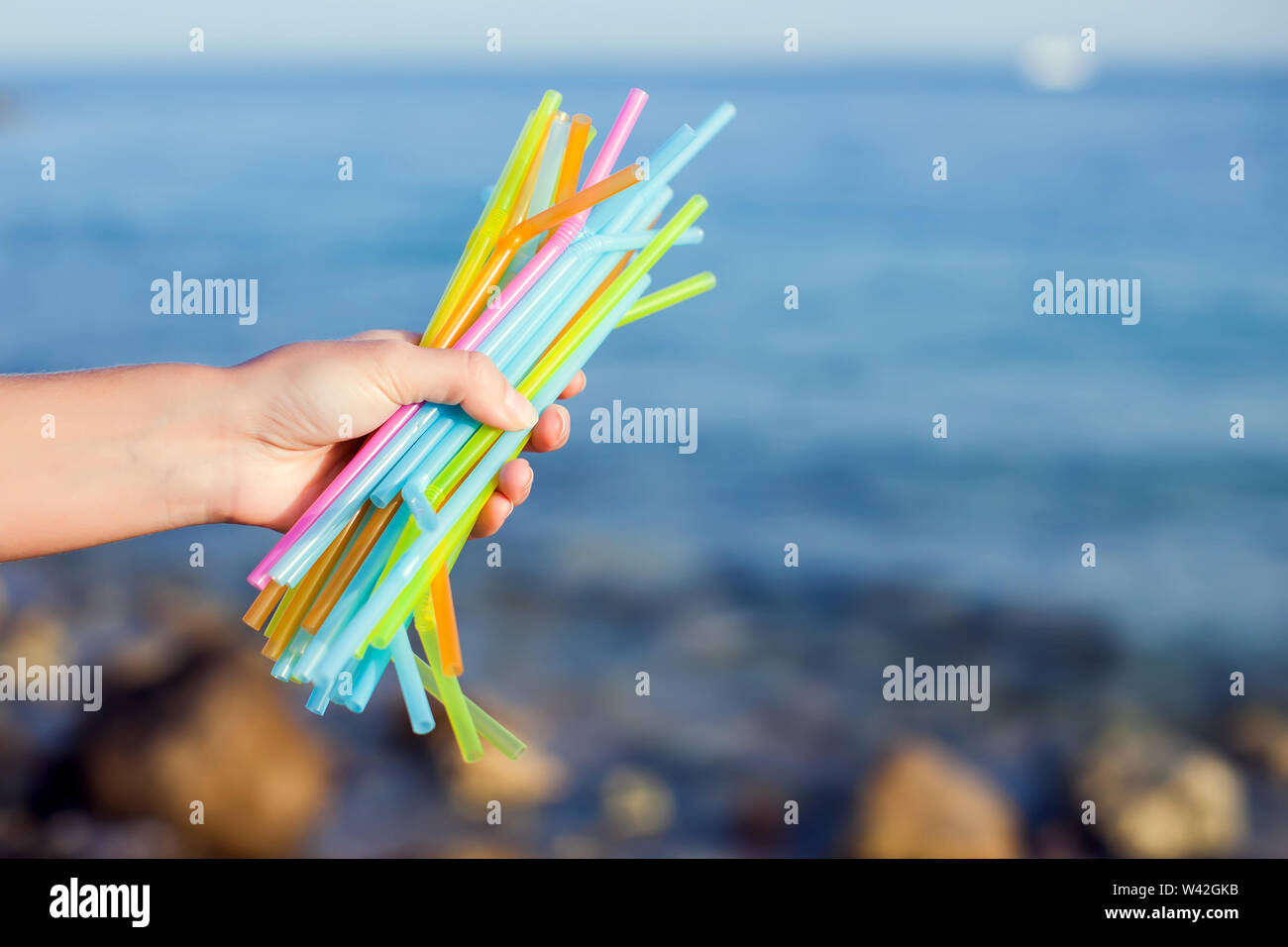 Close Up Of HandsHolding Plastic Straws Polluting Beach. Environmental ...