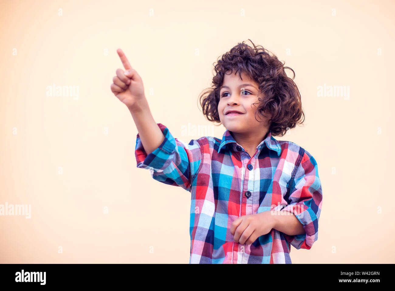 Arab boy pointing his finger with a smile on his face Stock Photo - Alamy