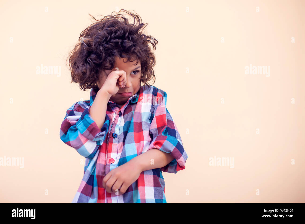 Sad kid with curly hair cry over isolated background Stock Photo - Alamy