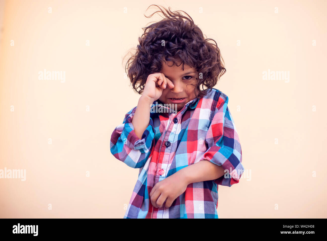 Sad kid with curly hair cry over isolated background Stock Photo - Alamy