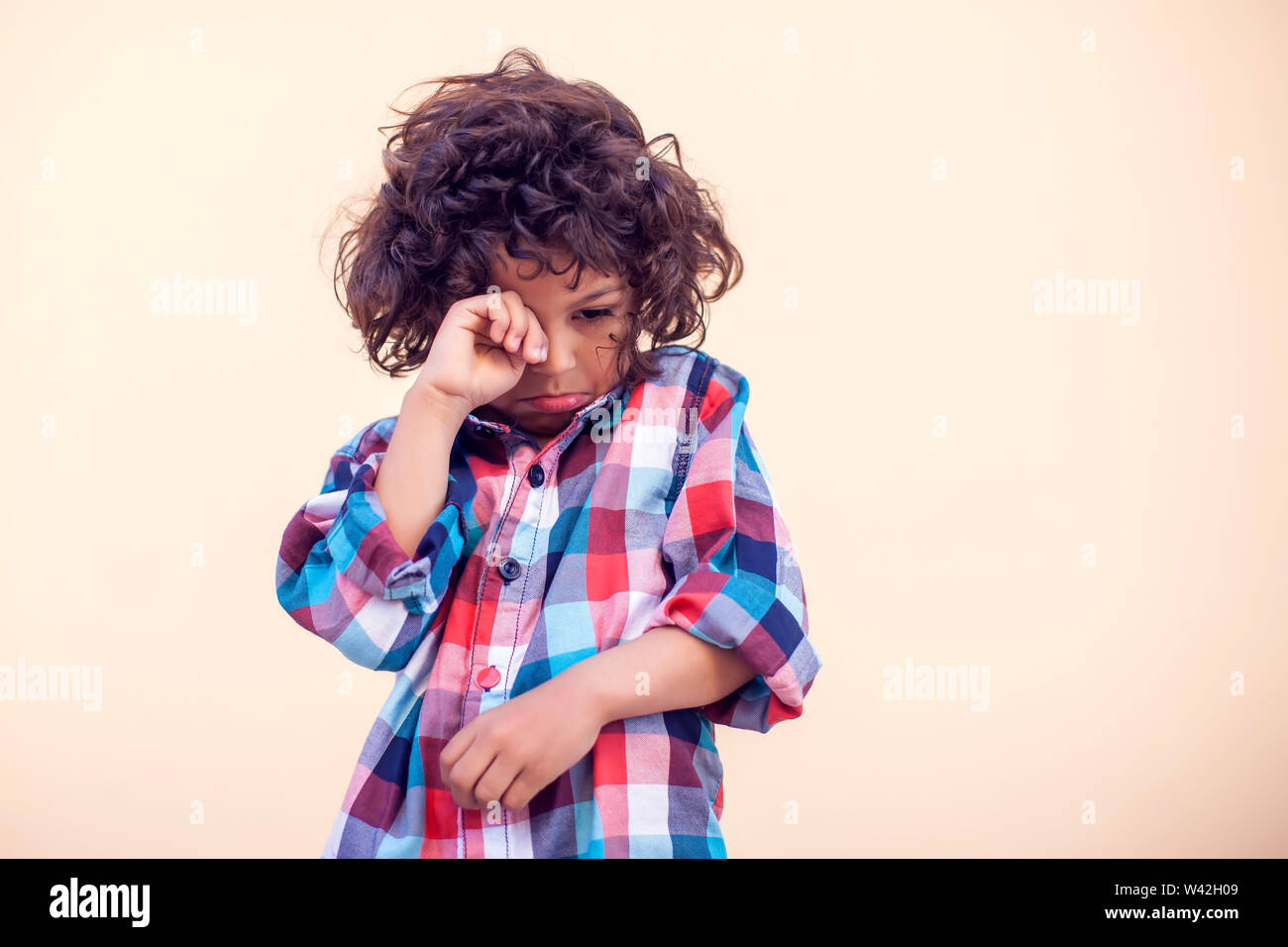 Sad kid with curly hair cry over isolated background Stock Photo - Alamy