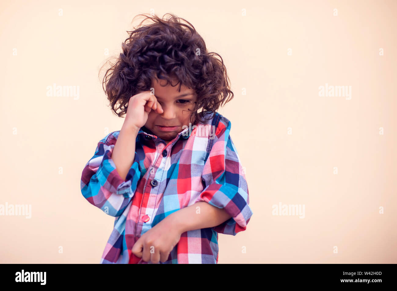 Sad kid with curly hair cry over isolated background Stock Photo - Alamy