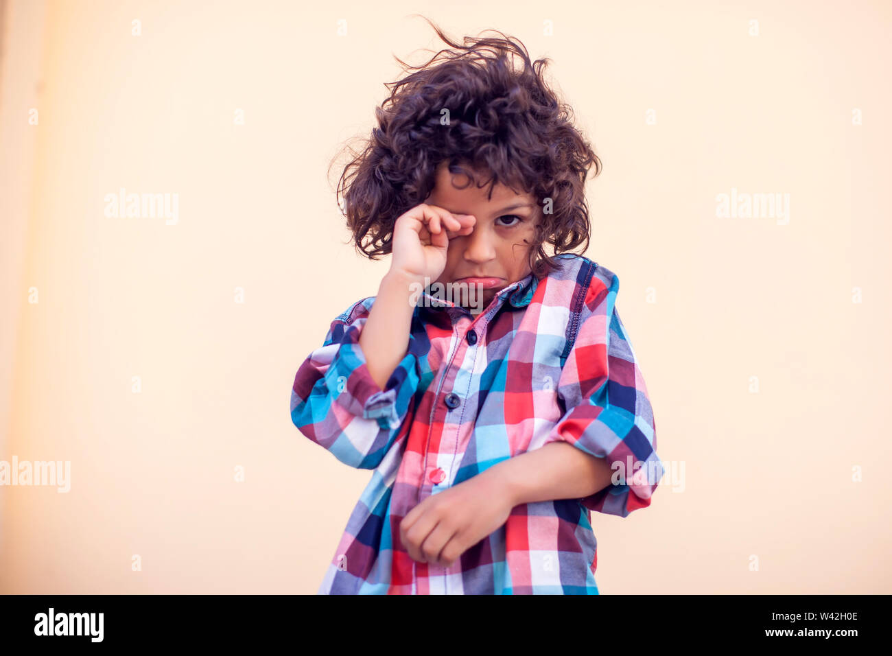 Sad kid with curly hair cry over isolated background Stock Photo - Alamy