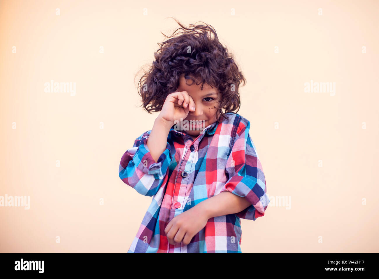 Sad kid with curly hair cry over isolated background Stock Photo - Alamy
