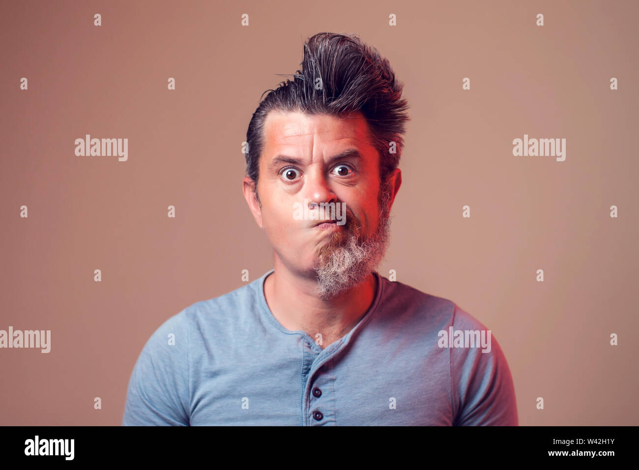 A portrait of man with half beard and hair on brown background Stock ...