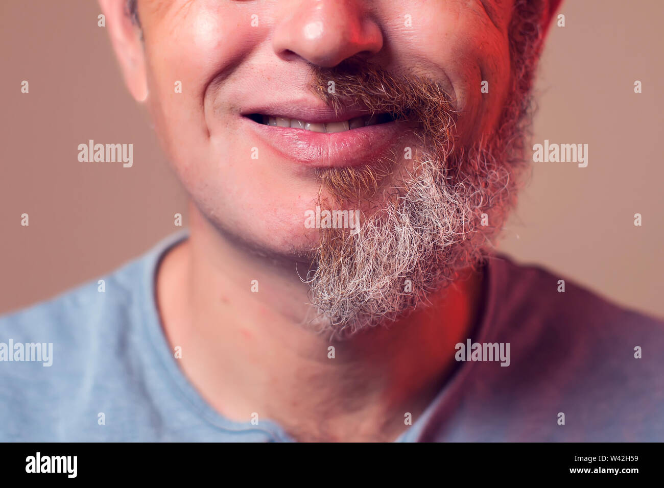 A portrait of man with half beard and hair on brown background Stock ...