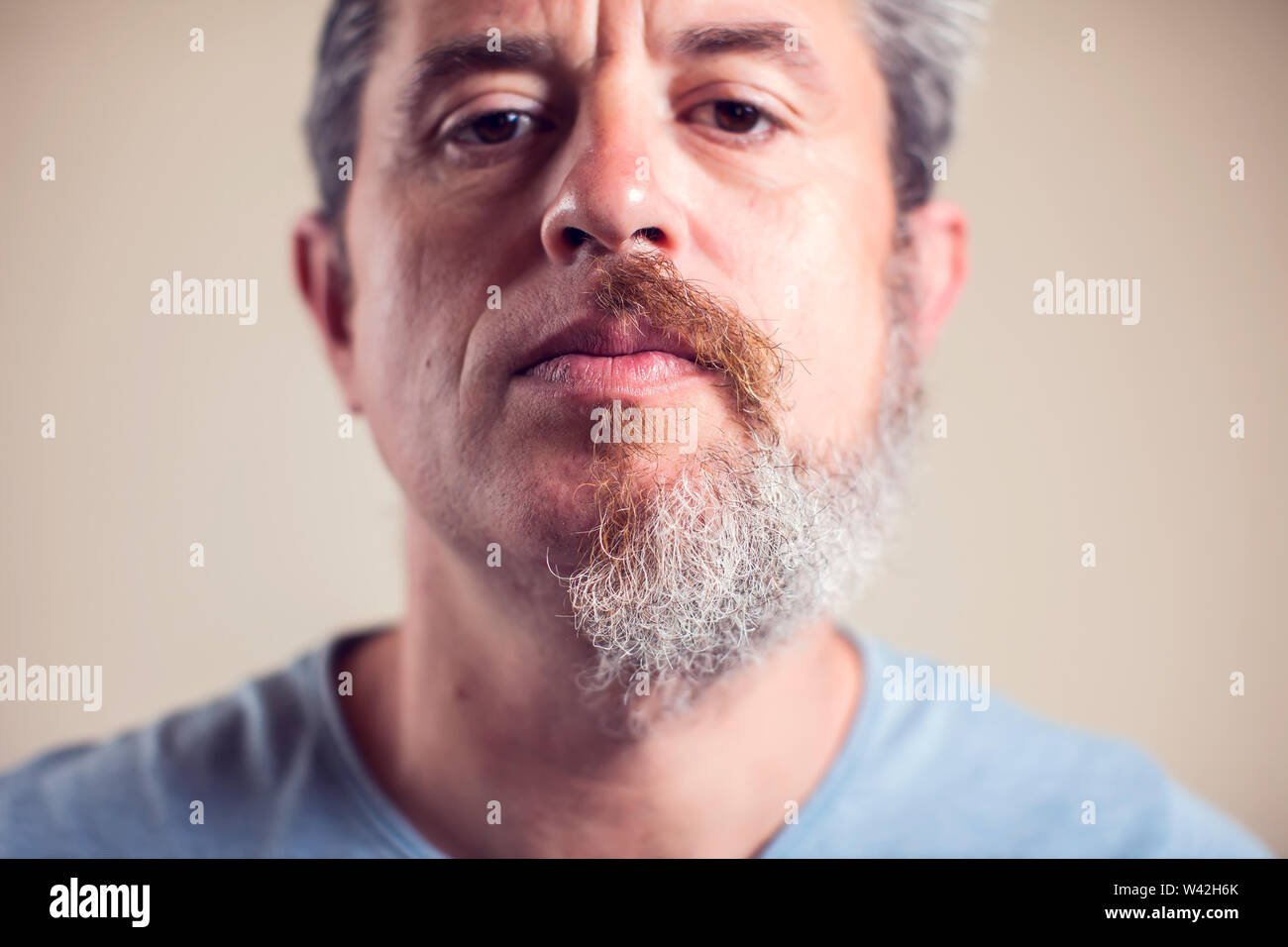 A portrait of man with half beard and hair on brown background Stock ...