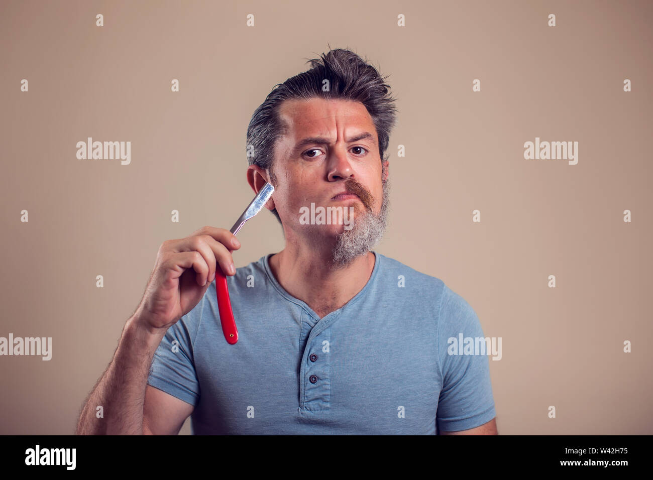 A portrait of man with half beard and hair on brown background Stock ...