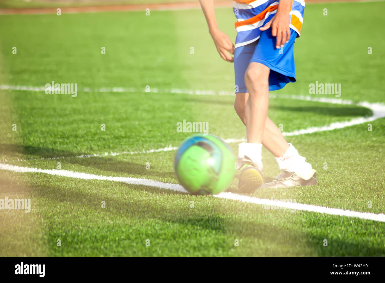 Foot of a child football player on the green football field Stock Photo ...