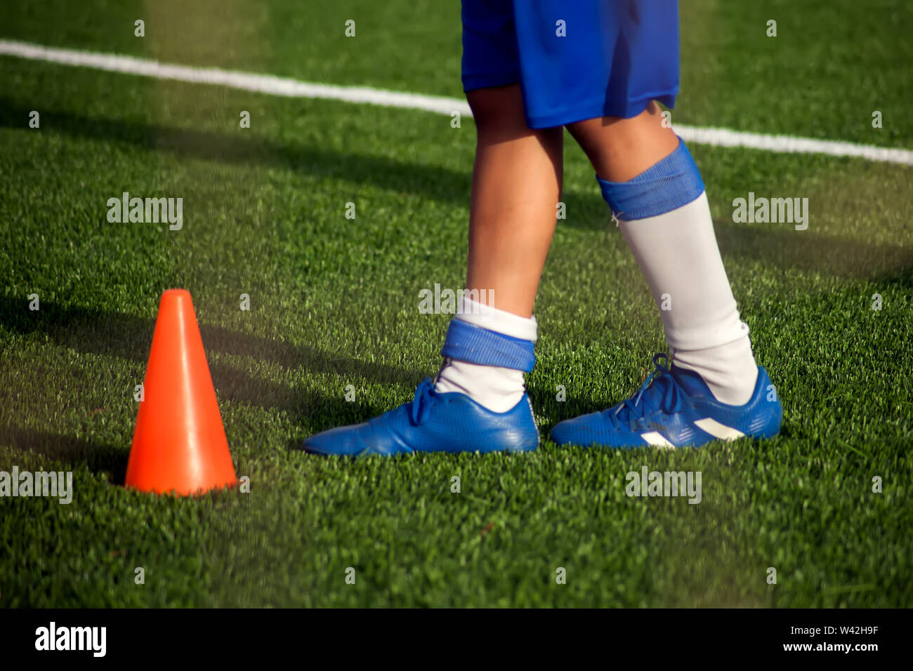 Foot of a child football player on the green football field Stock Photo ...