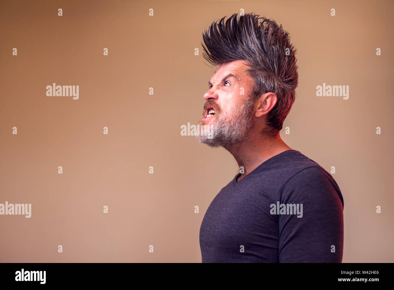 Closeup portrait of an angry adult man with a beard and iroquois ...