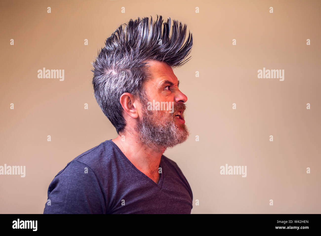 Closeup portrait of an angry adult man with a beard and iroquois ...