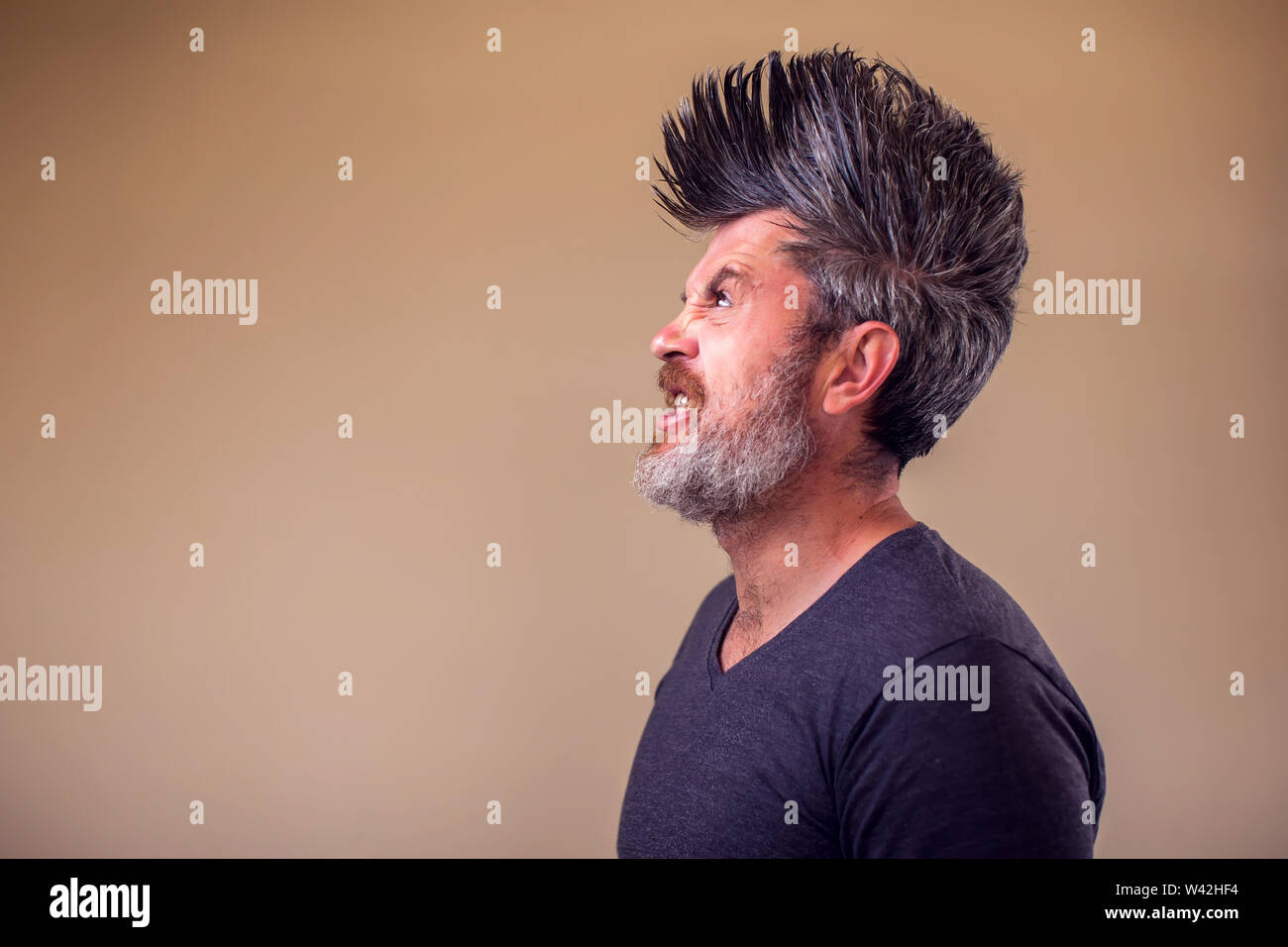 Closeup portrait of an angry adult man with a beard and iroquois ...