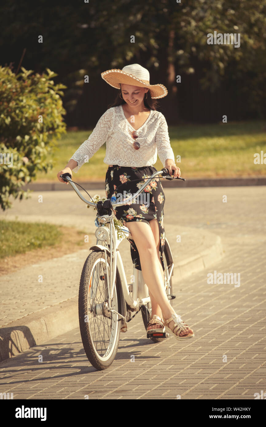 happy girl move on bicycle on street under sun rays Stock Photo - Alamy