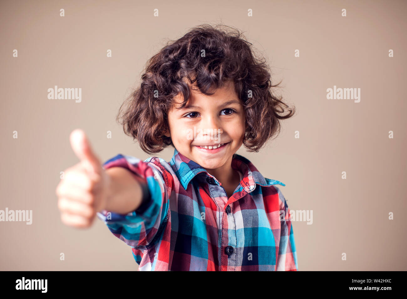 Little cute boy on grey background shows tumbs up gesture.. Children ...