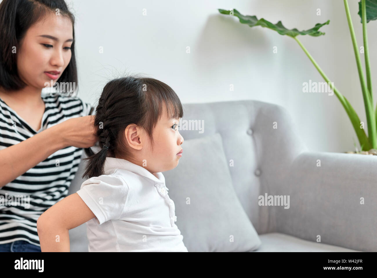 mother braiding hair of her daughter Stock Photo - Alamy