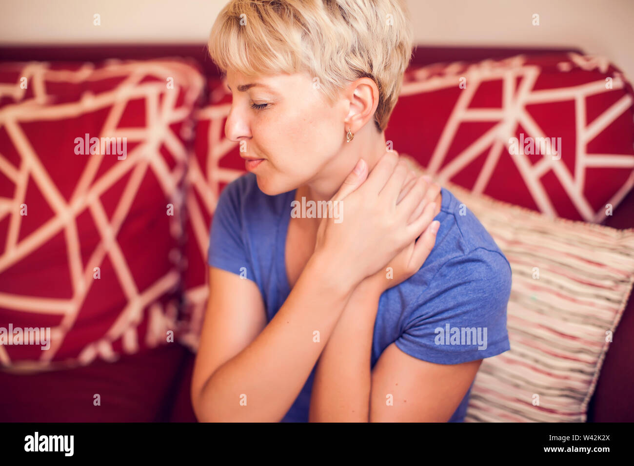 Woman feels strong neck pain at home. People, healthcare and medicine ...