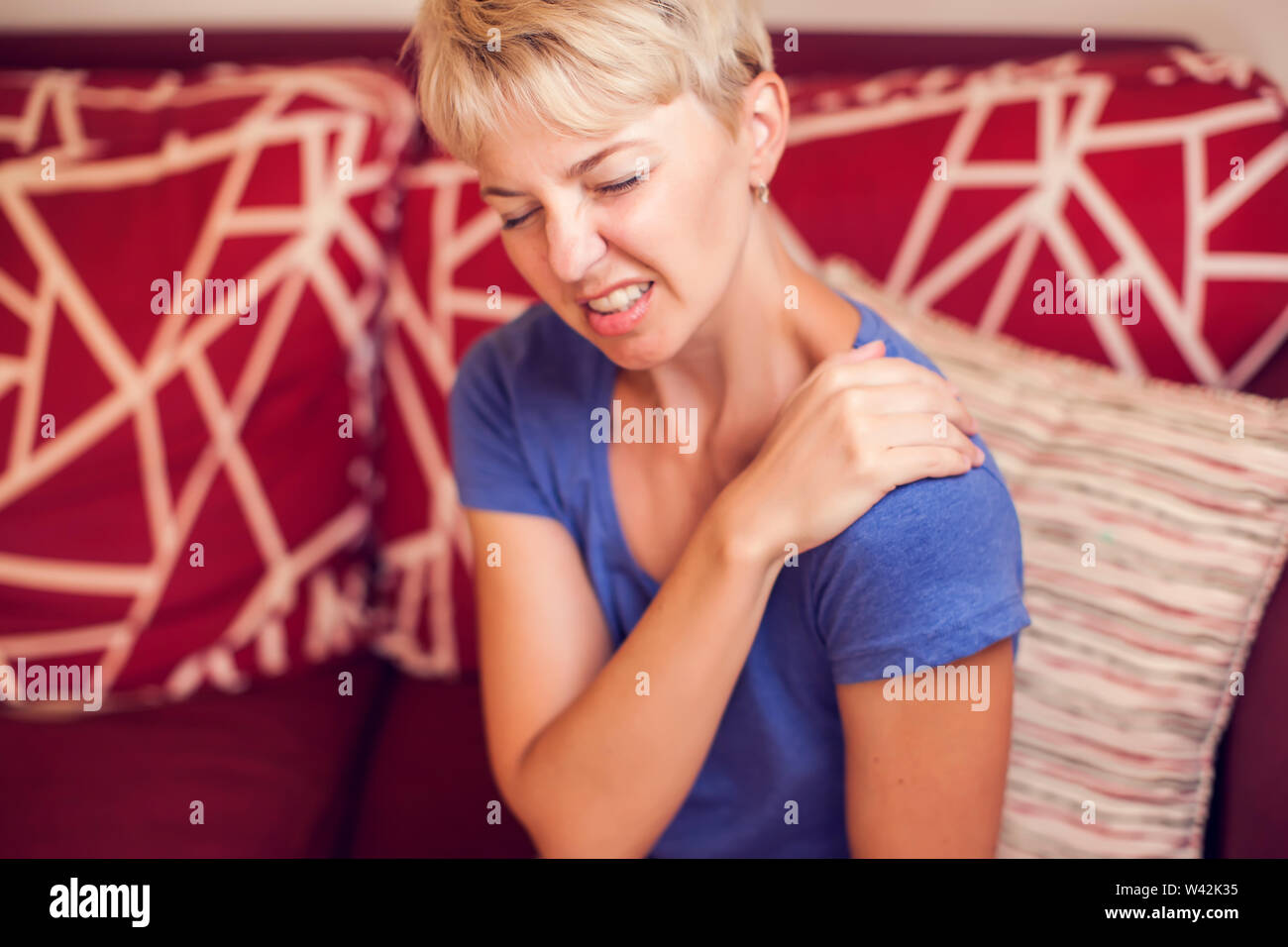 Woman feels strong neck pain at home. People, healthcare and medicine ...