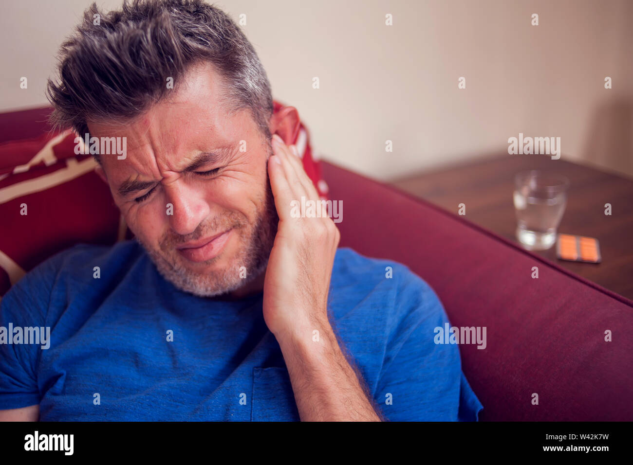 Man feels strong ear pain at home. People, healthcare and medicine ...