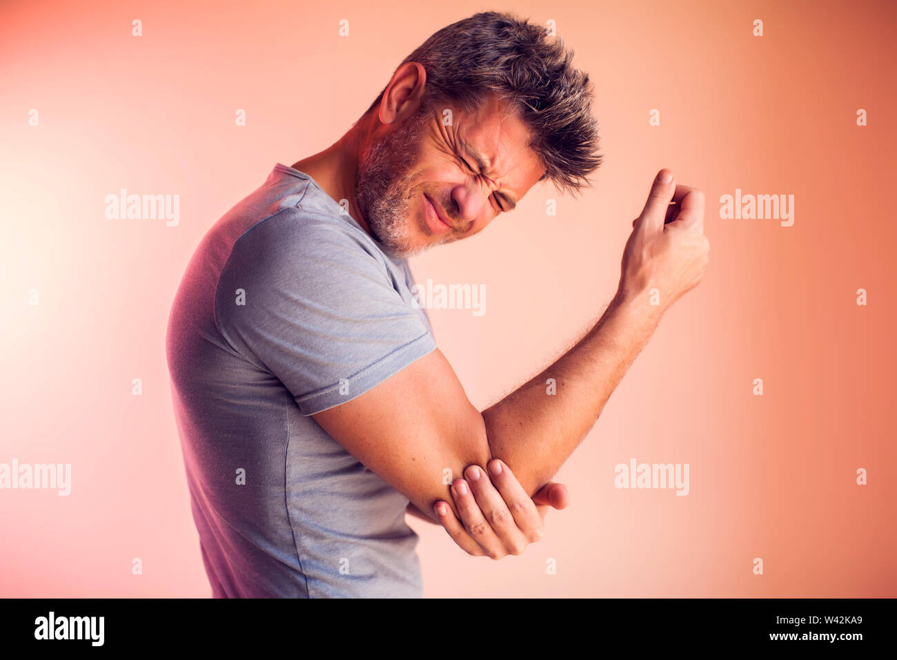 Man feels strong pain in elbow. People, healthcare and medicine concept ...