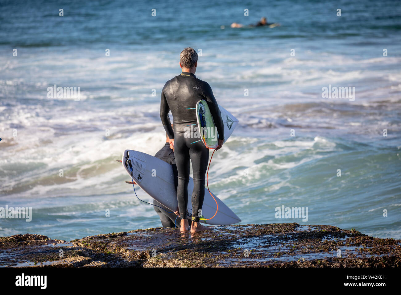 Surfer, man carrying his surfboard ready for a surfing afternoon on ...