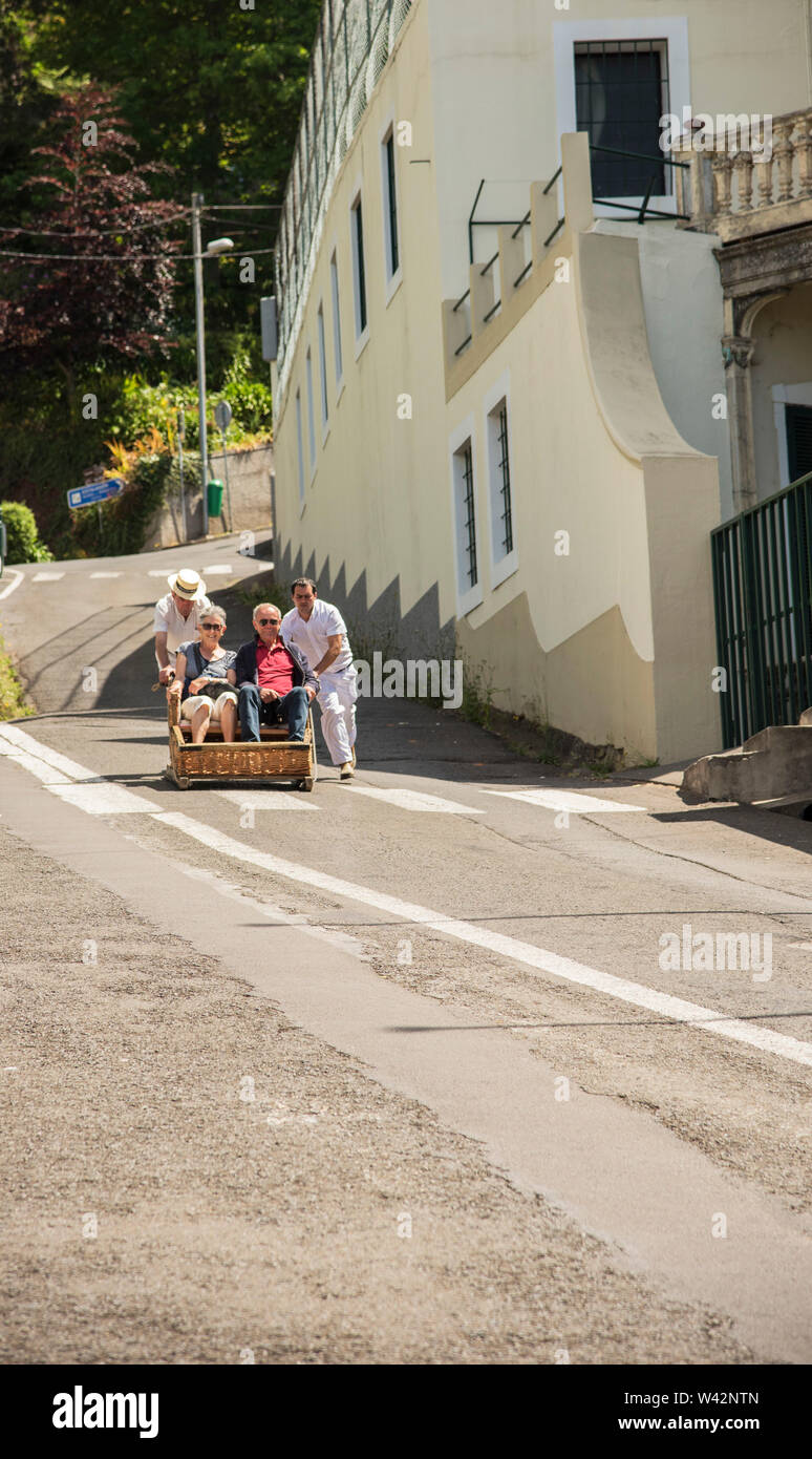 People taking a ride on the famous Funchal basket sledge down a steep ...